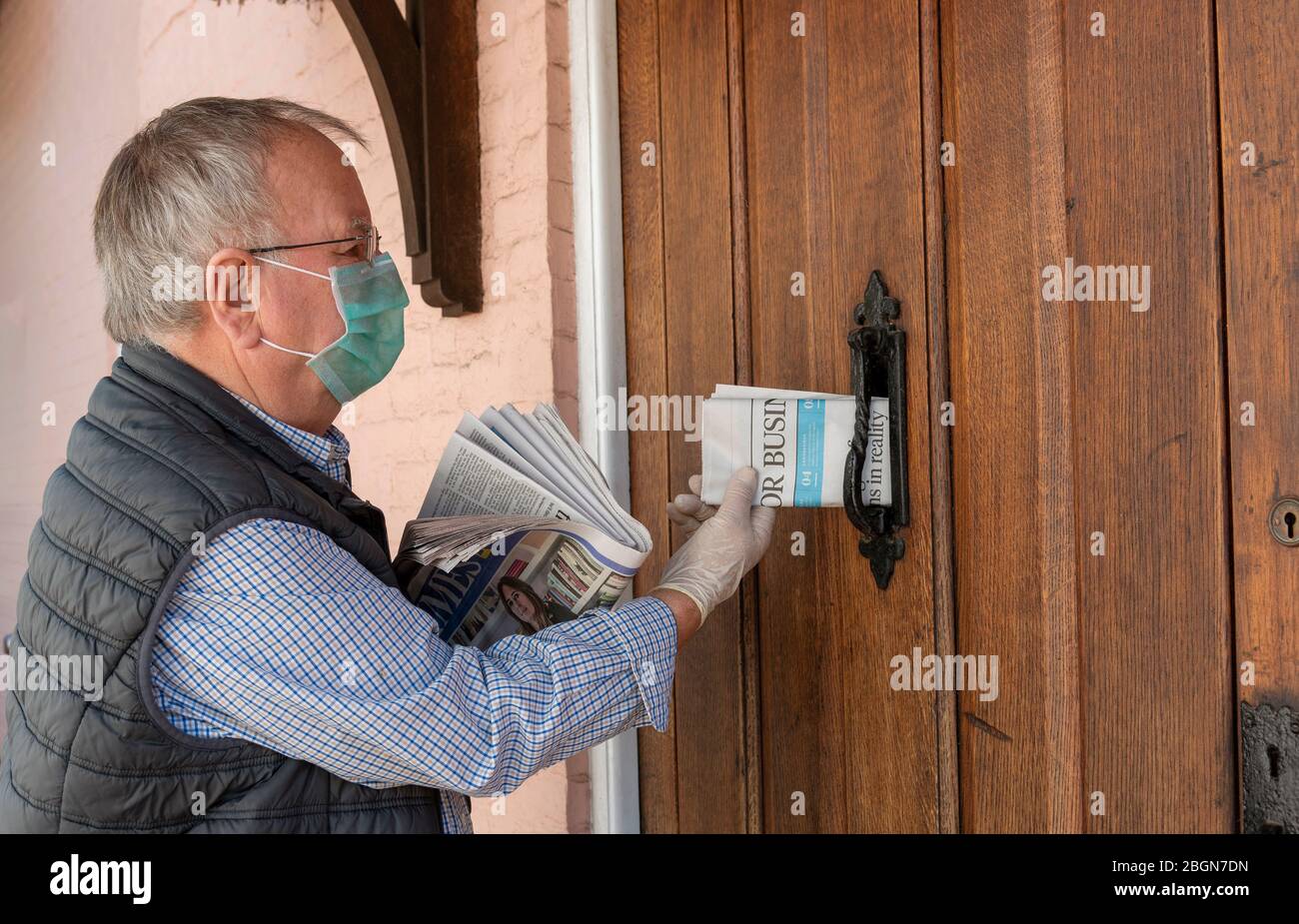 Hampshire, UK.2020. Newspaper delivery man wearing protective mask and ...