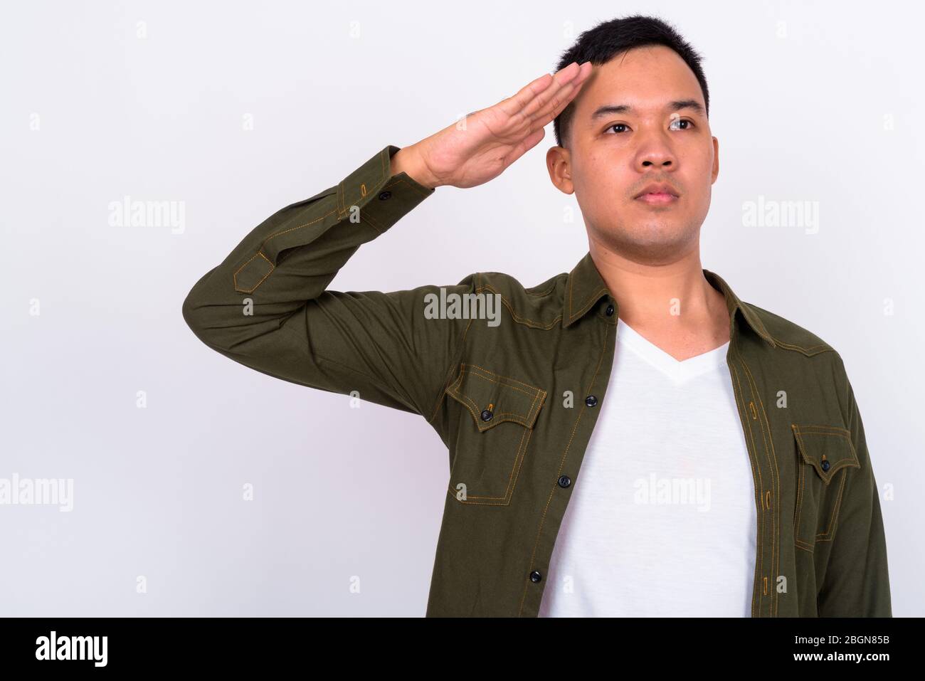 Portrait of young Asian man saluting while looking away Stock Photo - Alamy