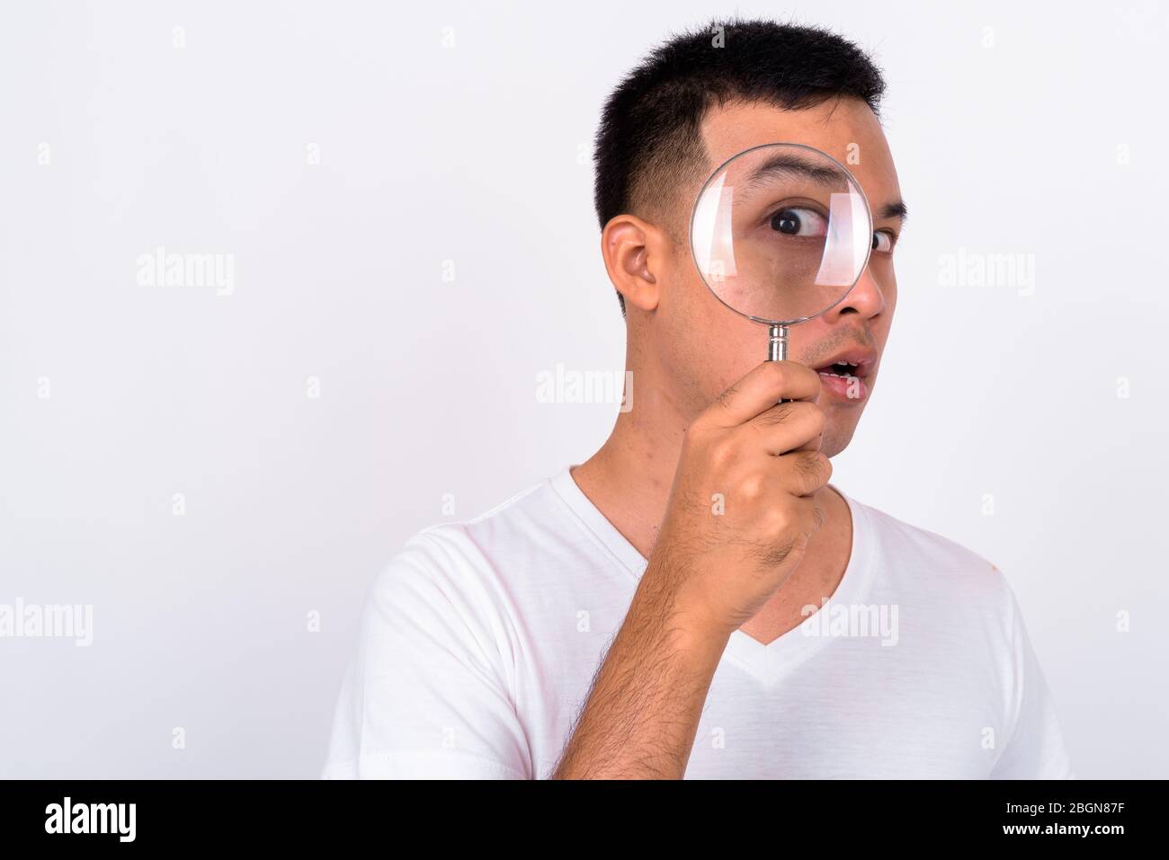 Face of young Asian man using magnifying glass Stock Photo - Alamy