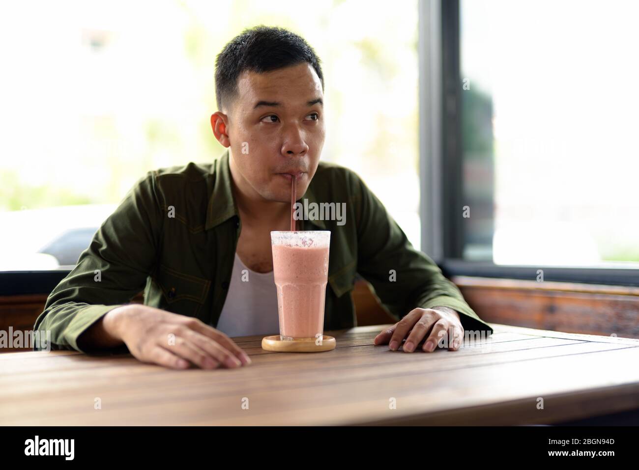 Young Asian man drinking shake at the coffee shop Stock Photo - Alamy