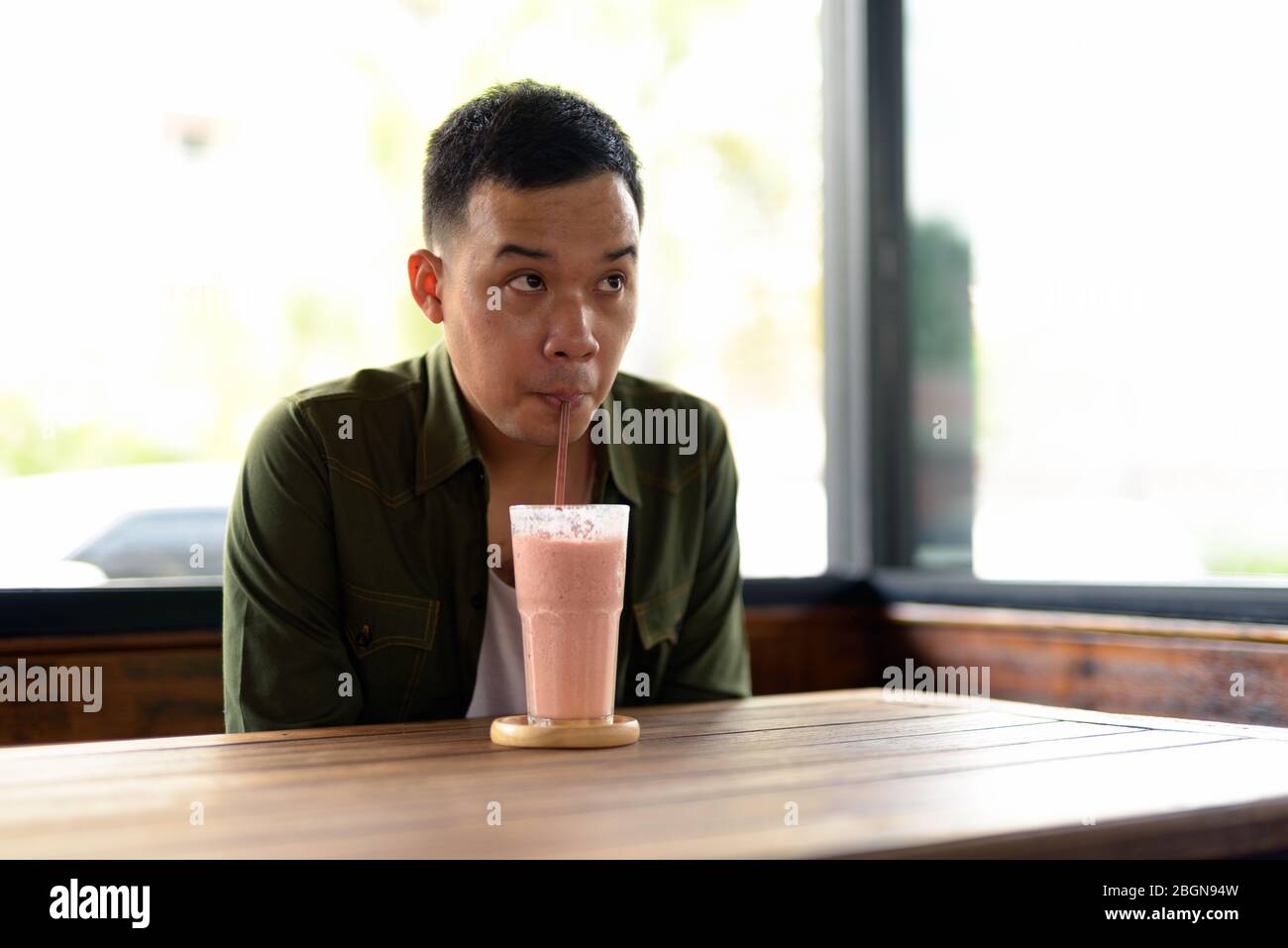 Young Asian man drinking shake at the coffee shop Stock Photo - Alamy