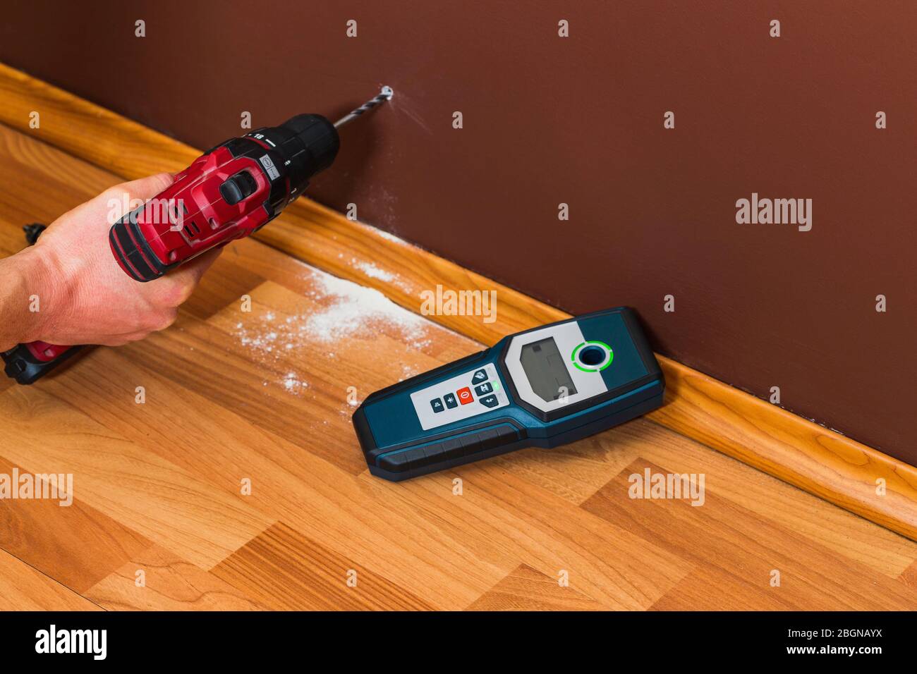 Man hand is scanning wall by cable detector to find a cable before ...