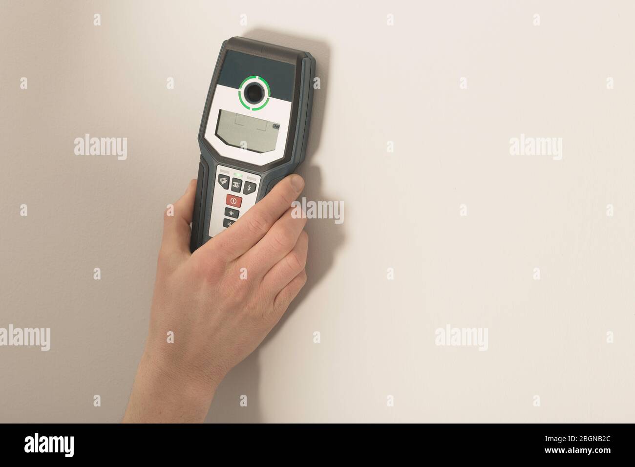 Man hand is scanning wall by cable detector to find a cable before ...