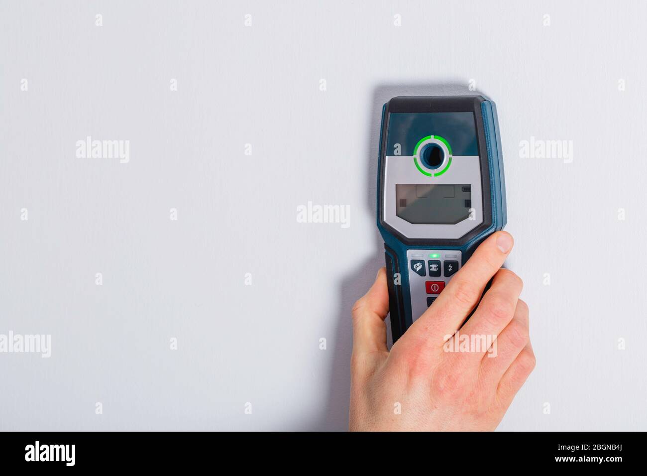 Man hand is scanning wall by cable detector to find a cable before ...