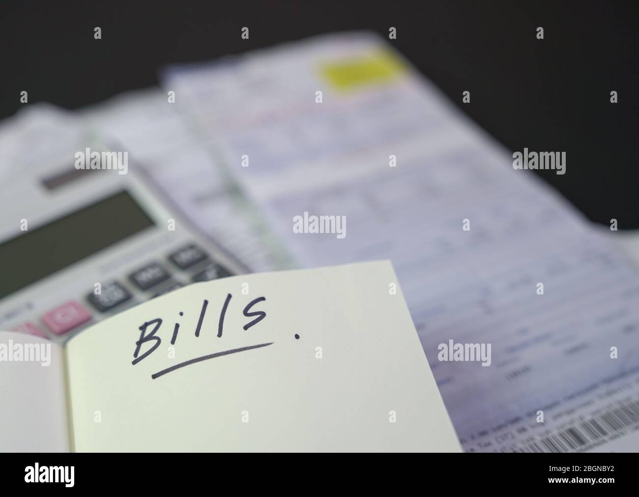 Notepad with the words, Bills and calculator and stack of bill notes at ...