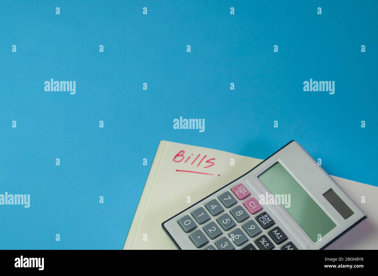 Bills. Notepad with calculator on top of blue color table. Copy space ...