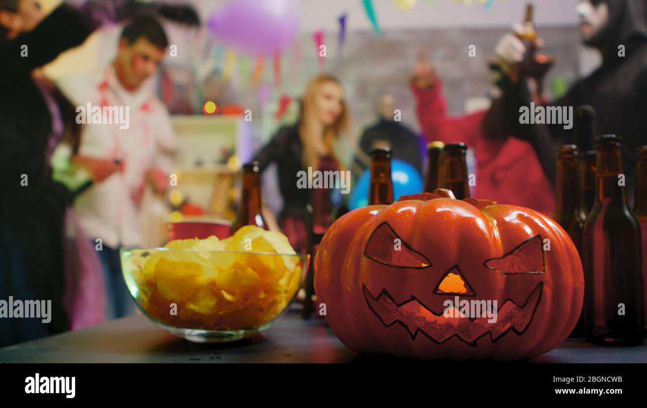 Scary pumpkin on the party while group of people are dancing ...