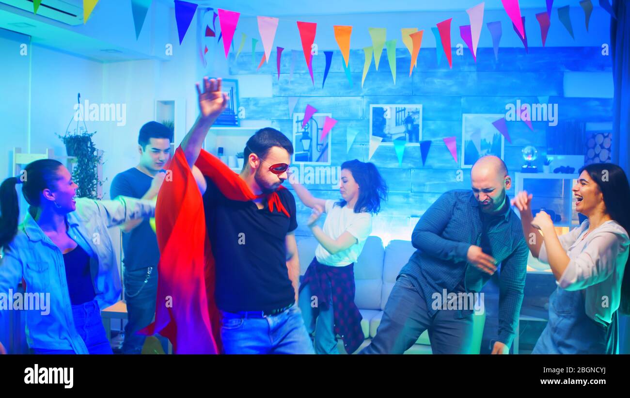 Cheerful young man wearing a superhero red cape showing his dancing ...