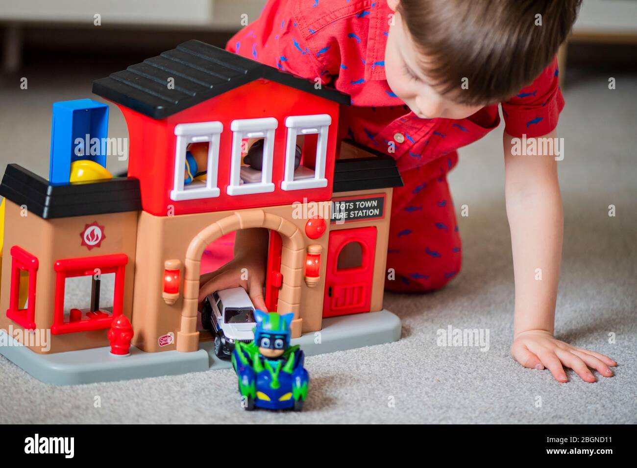 A young boy plays with a toy fire station Stock Photo - Alamy