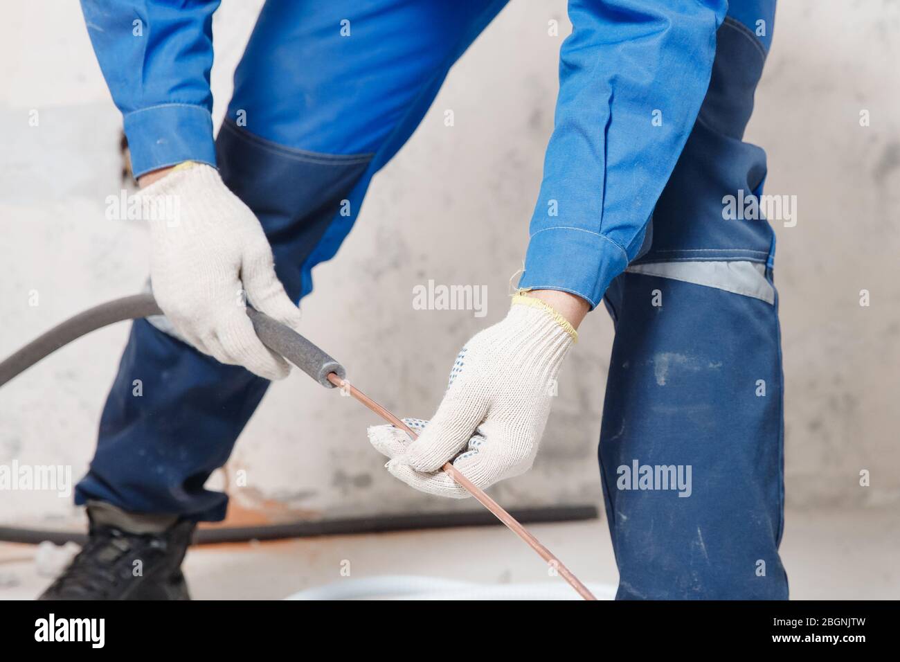 Worker man Installation of pipe channel for connecting air conditioner ...