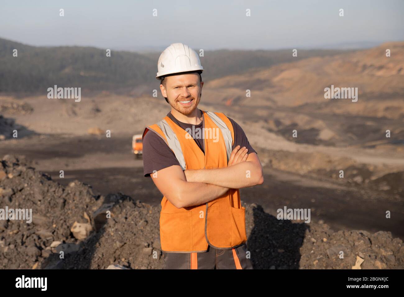 Engineer smiling man in white helmet on background open pit mine ...