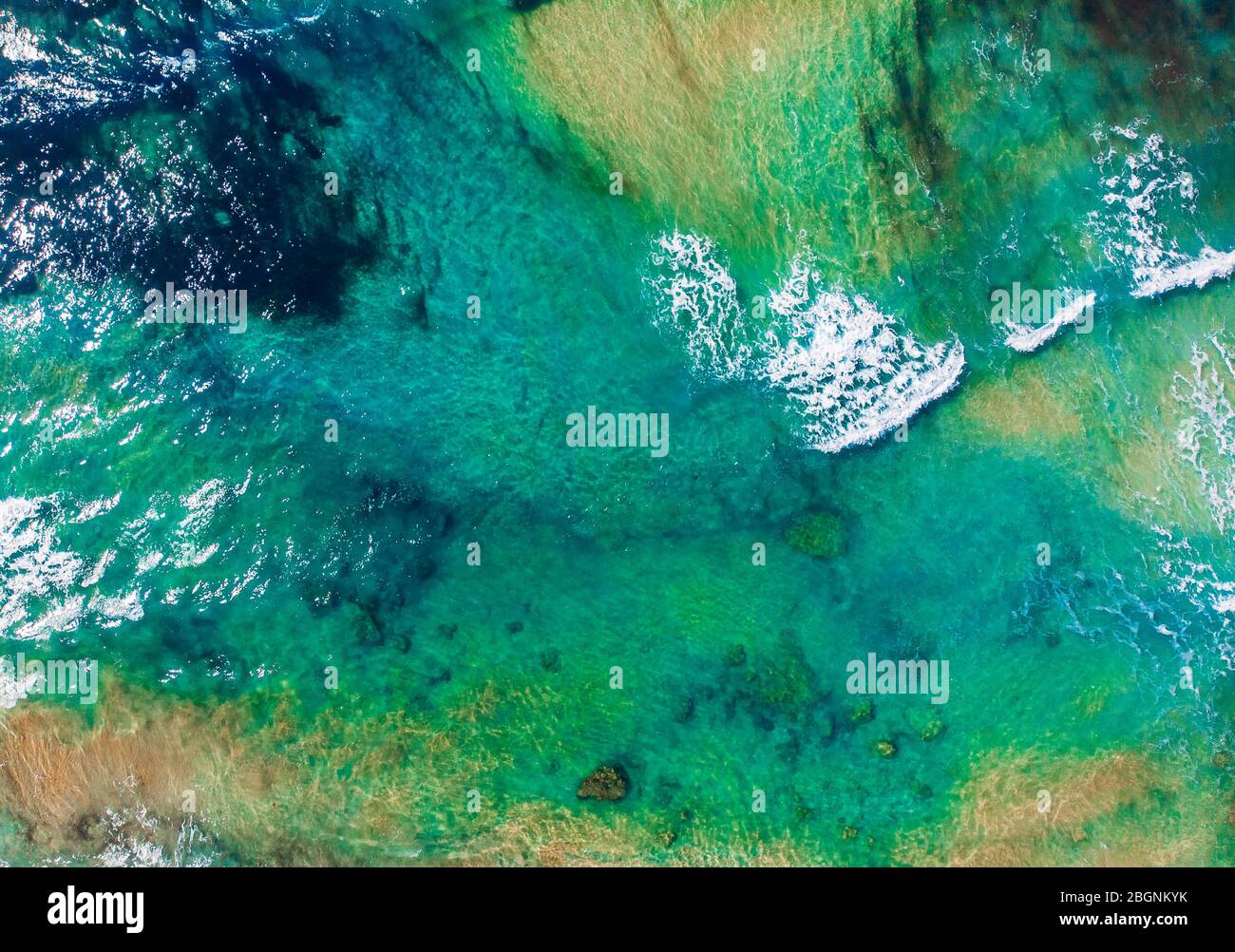 Small turquoise waves for surfing on shallows of sea low tide or ebb ...