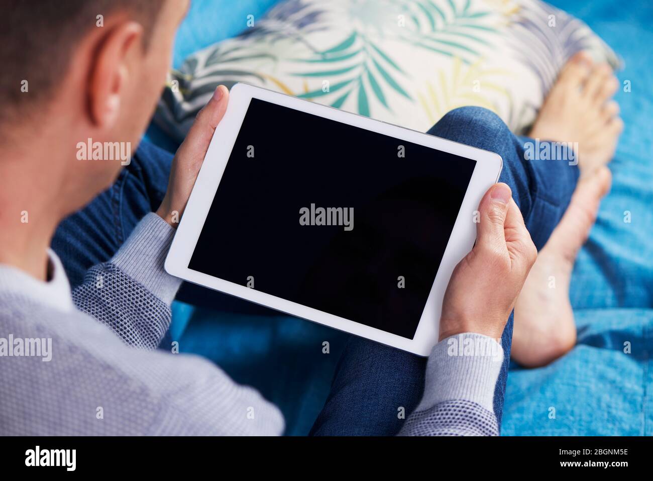 closeup of a young caucasian man, lying comfortably on a couch ...