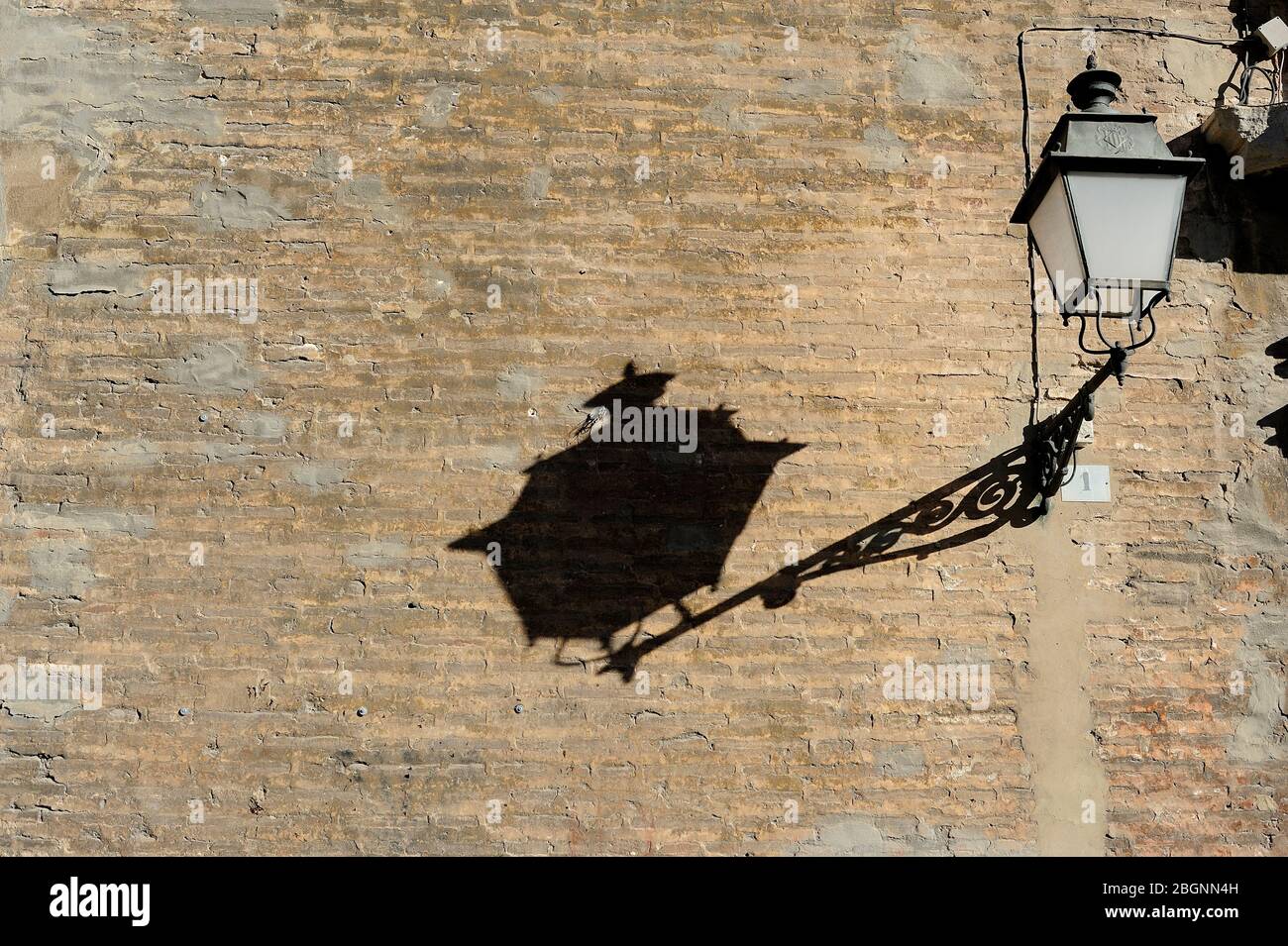 lantern casting shadow on stone wall Stock Photo - Alamy