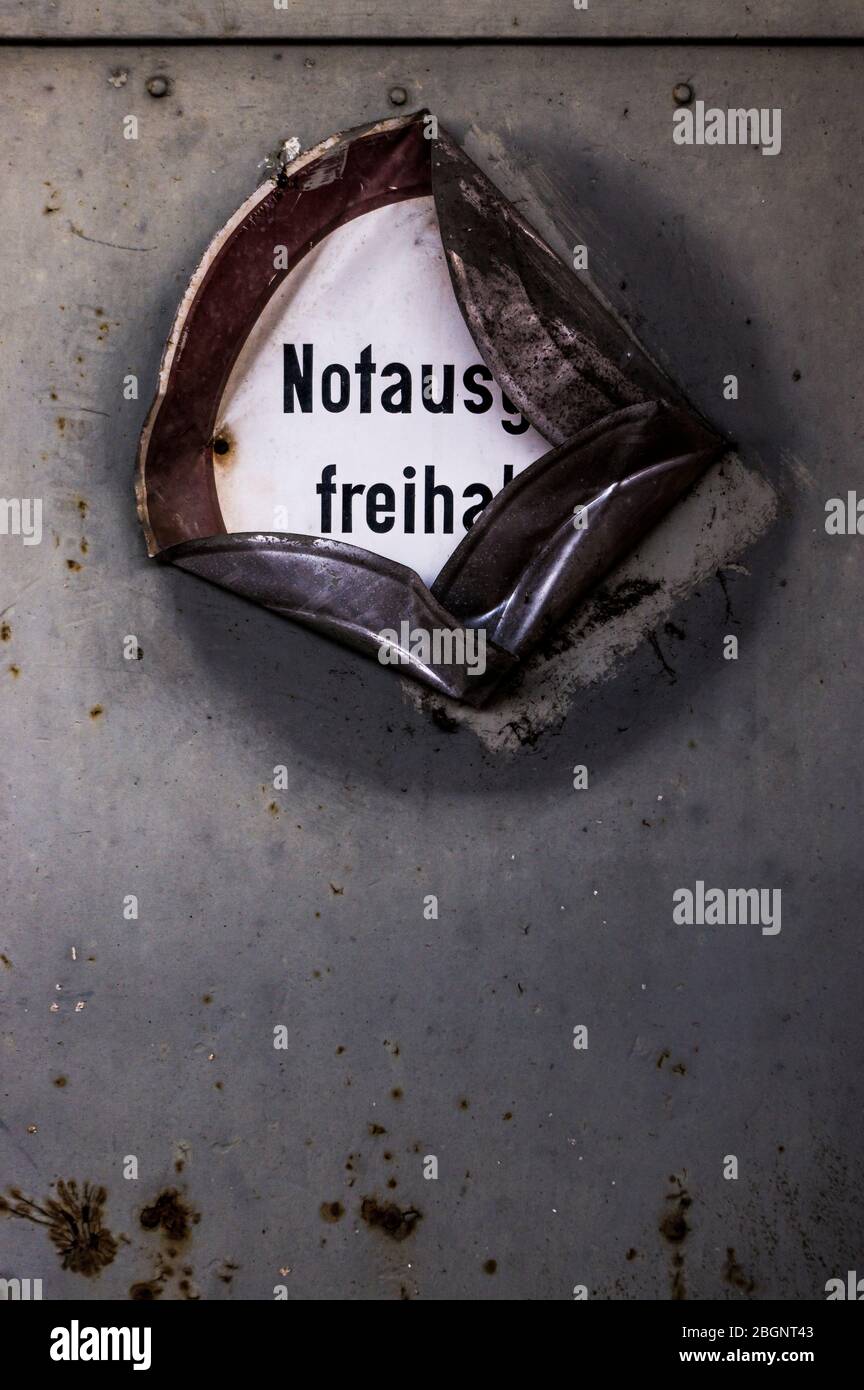 old dented metal sign Emergency exit free at weathered metal door with ...