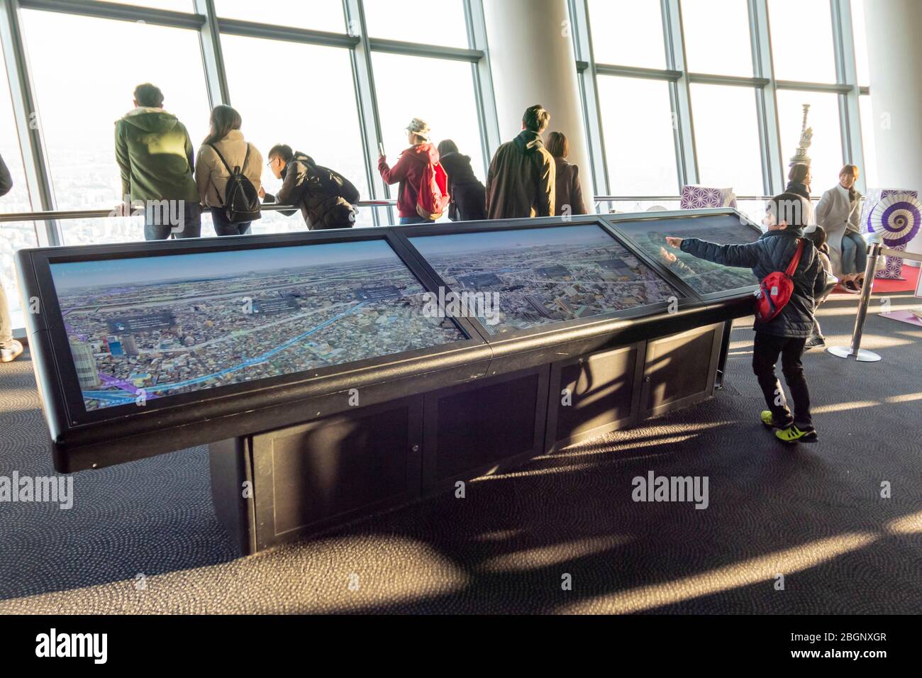 A boy in learning Tokyo city map through very big touch screen in Tokyo ...