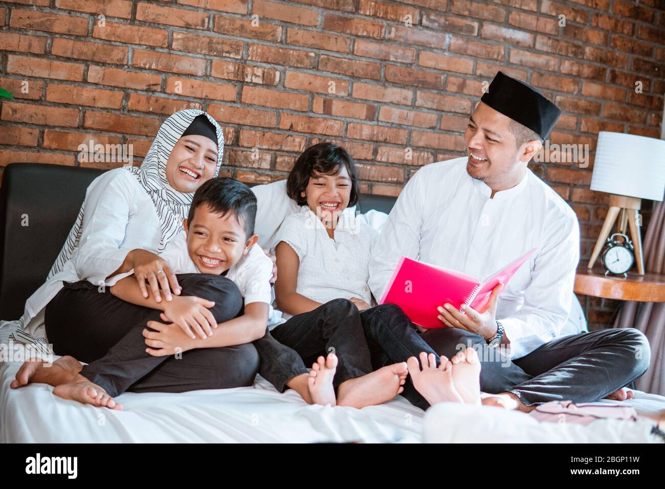 family with two kids read books together. muslim asian family Stock ...