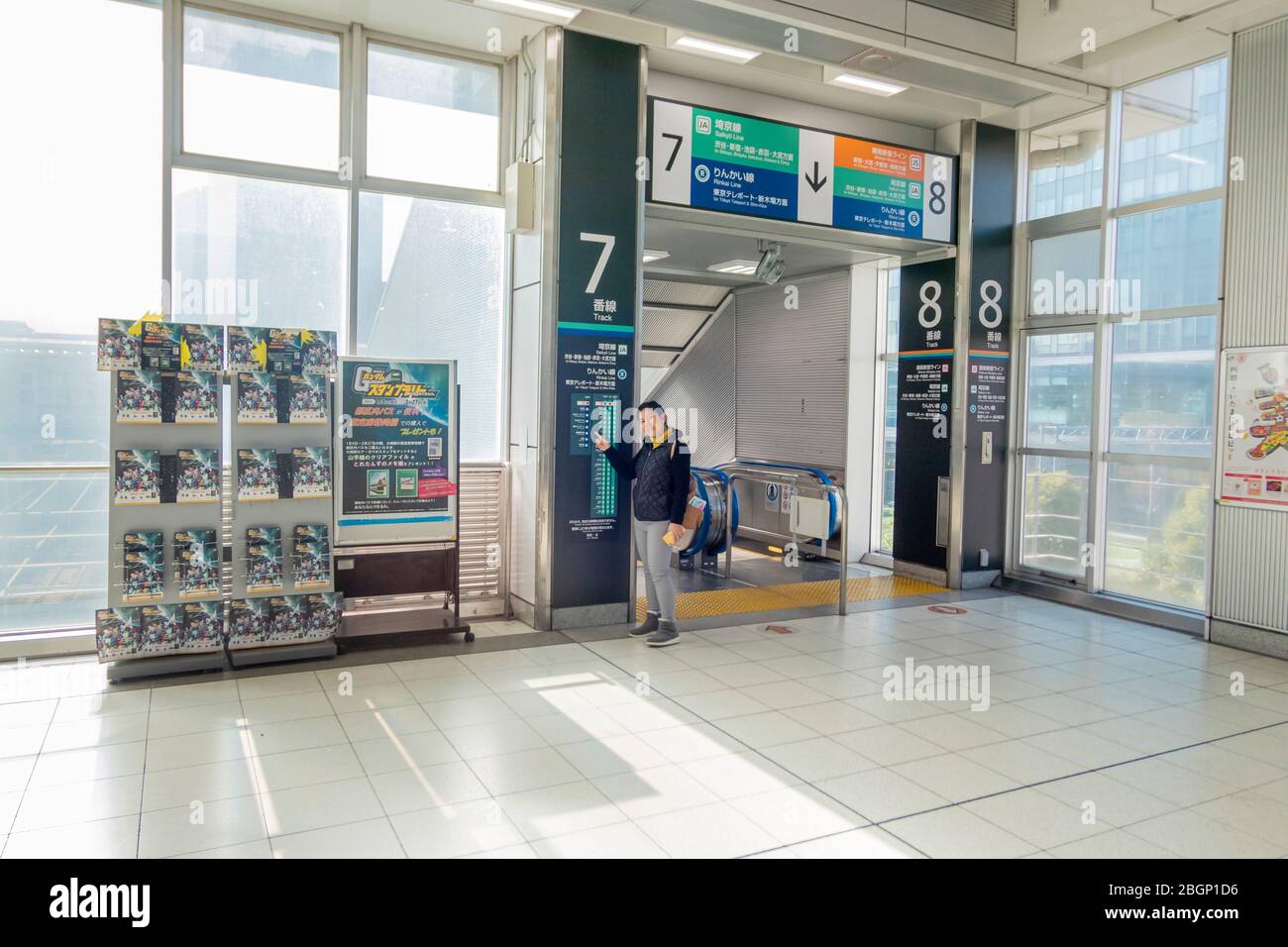 An Asian woman standing at the train number entrance at Tokyo subway ...