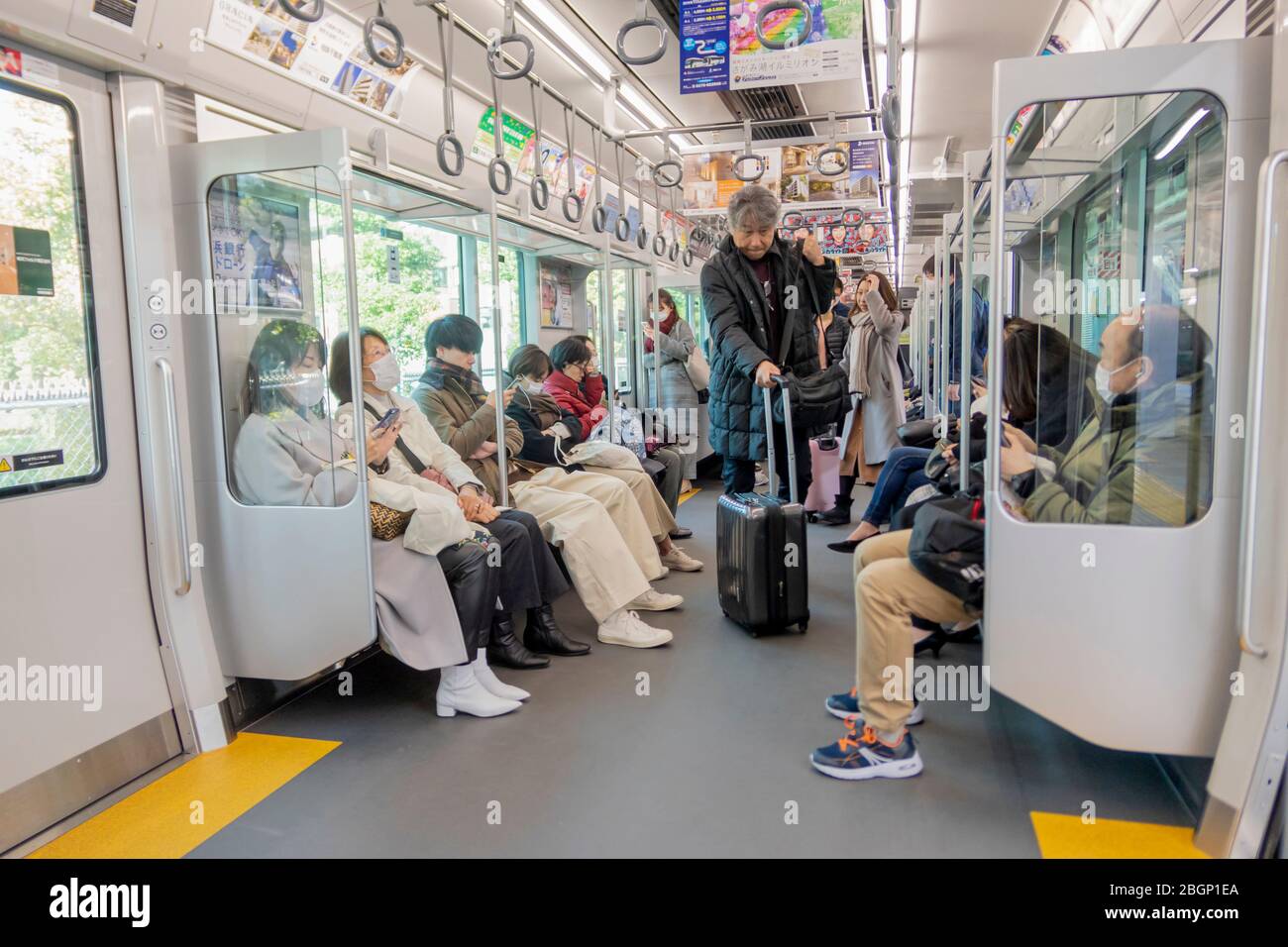 Japanese people in the subway train, some are wearing masks to protect ...