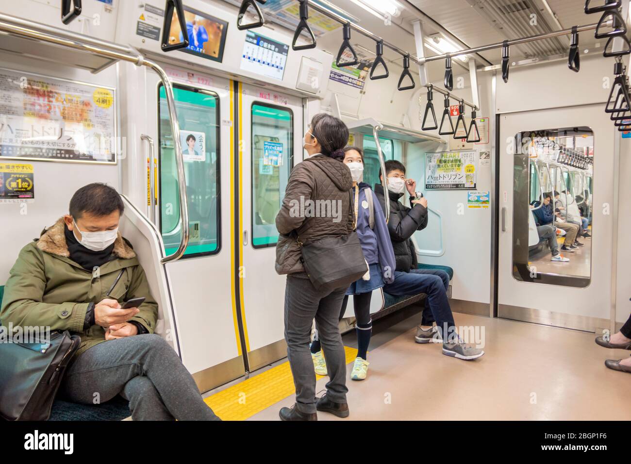 Japanese people in the subway train, some are wearing masks to protect ...