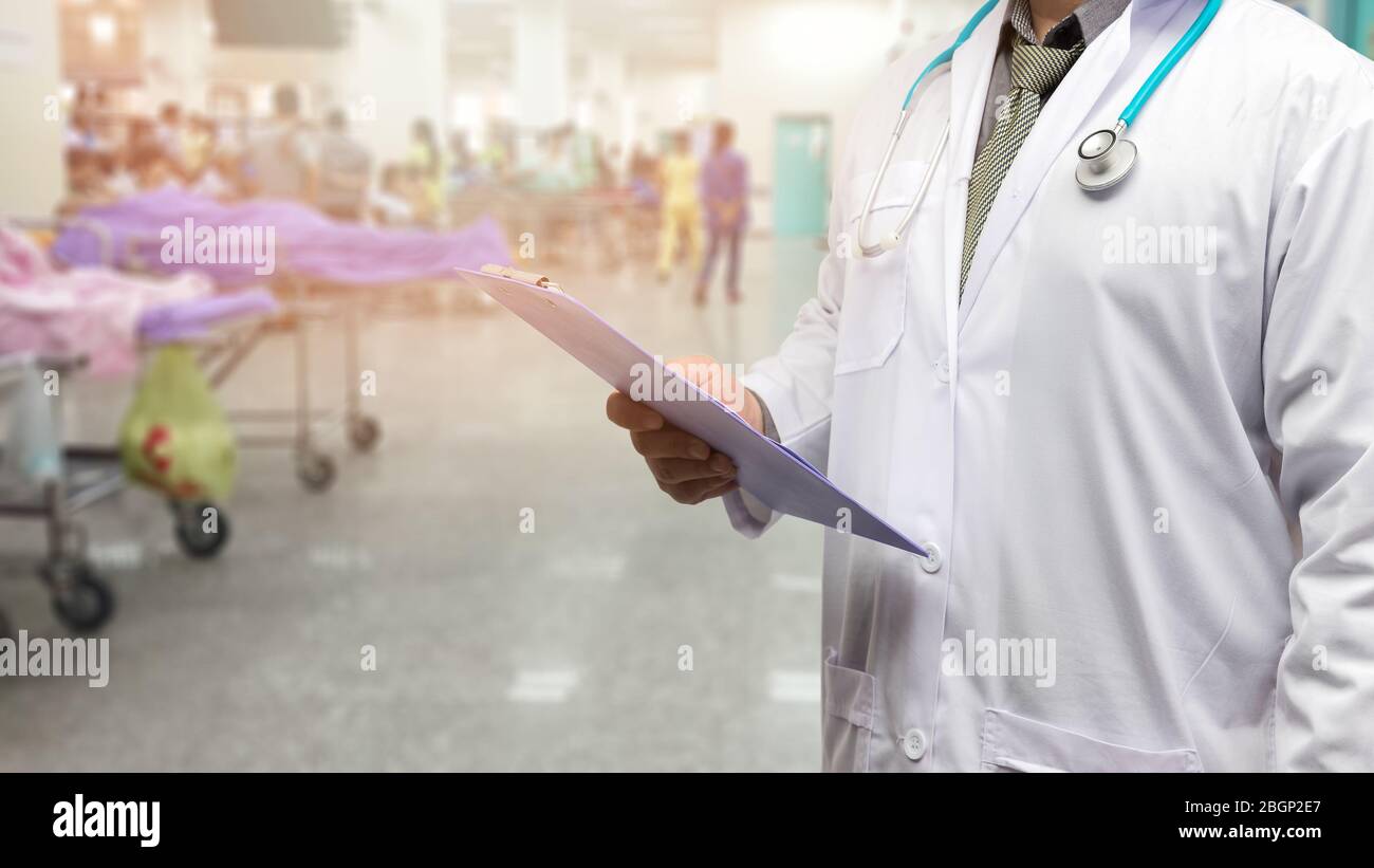 Doctor in gown uniform with patient chart standing on patient screening ...