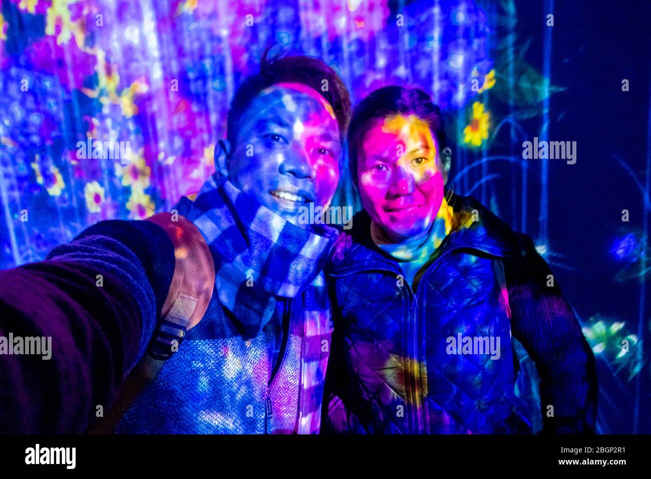 An Asian couple selfies with projector and reflecting light effect art ...