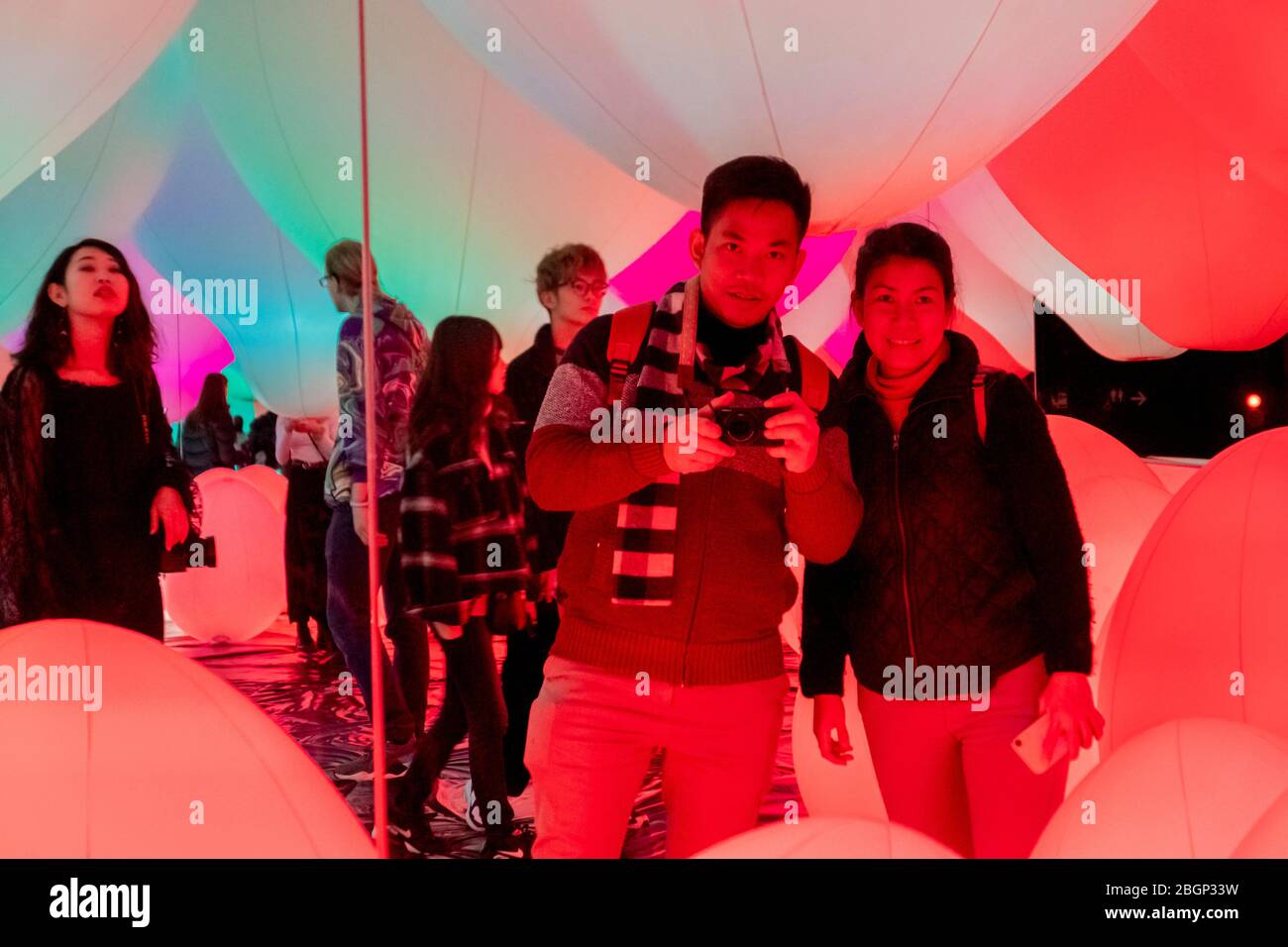 An Asian couple selfies with projector and reflecting light effect art ...