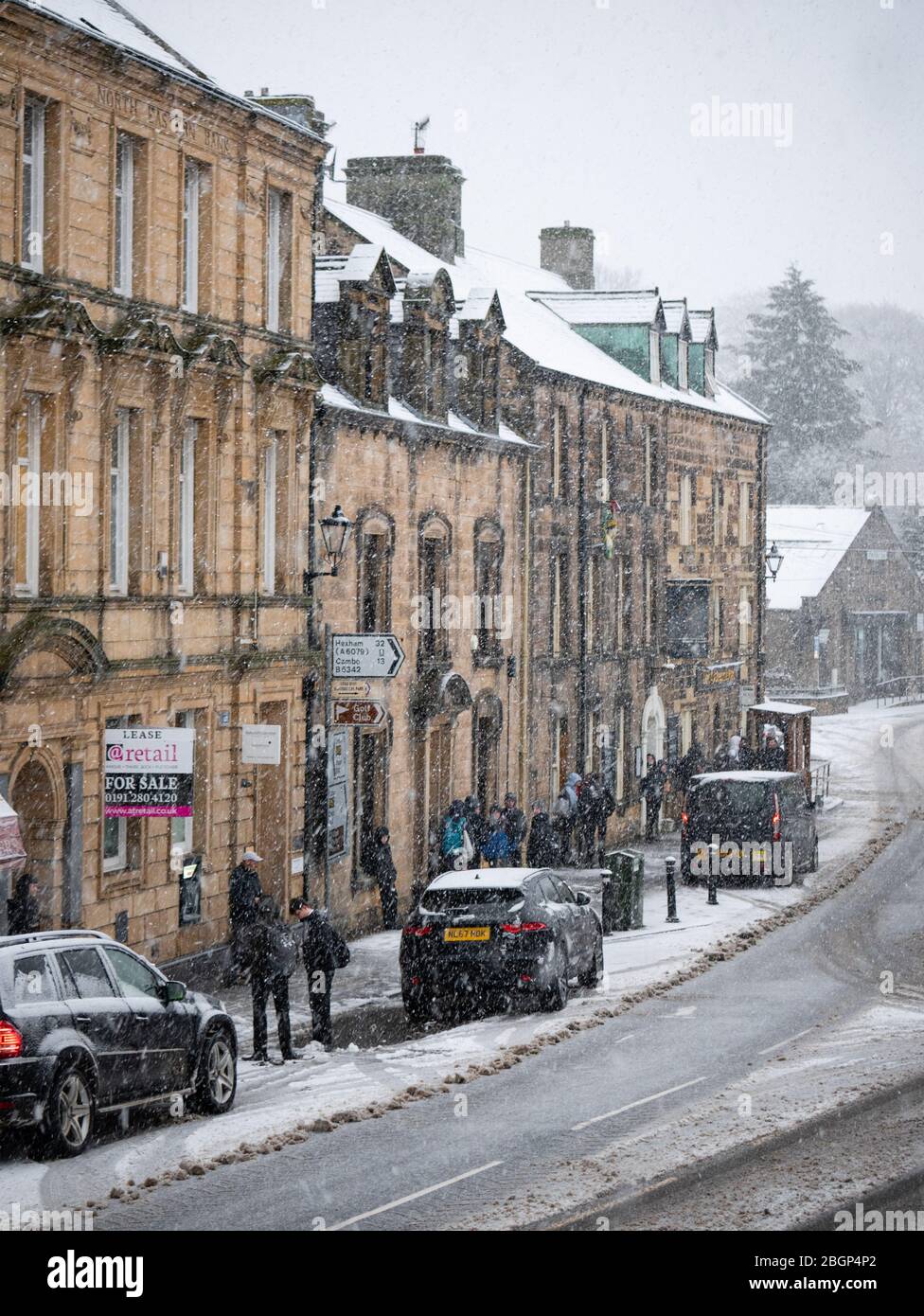 Schoolchildren queuing for a bus in the snow whilst waiting for a snow ...