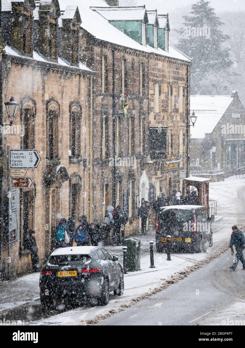 Schoolchildren queuing for a bus in the snow whilst waiting for a snow ...