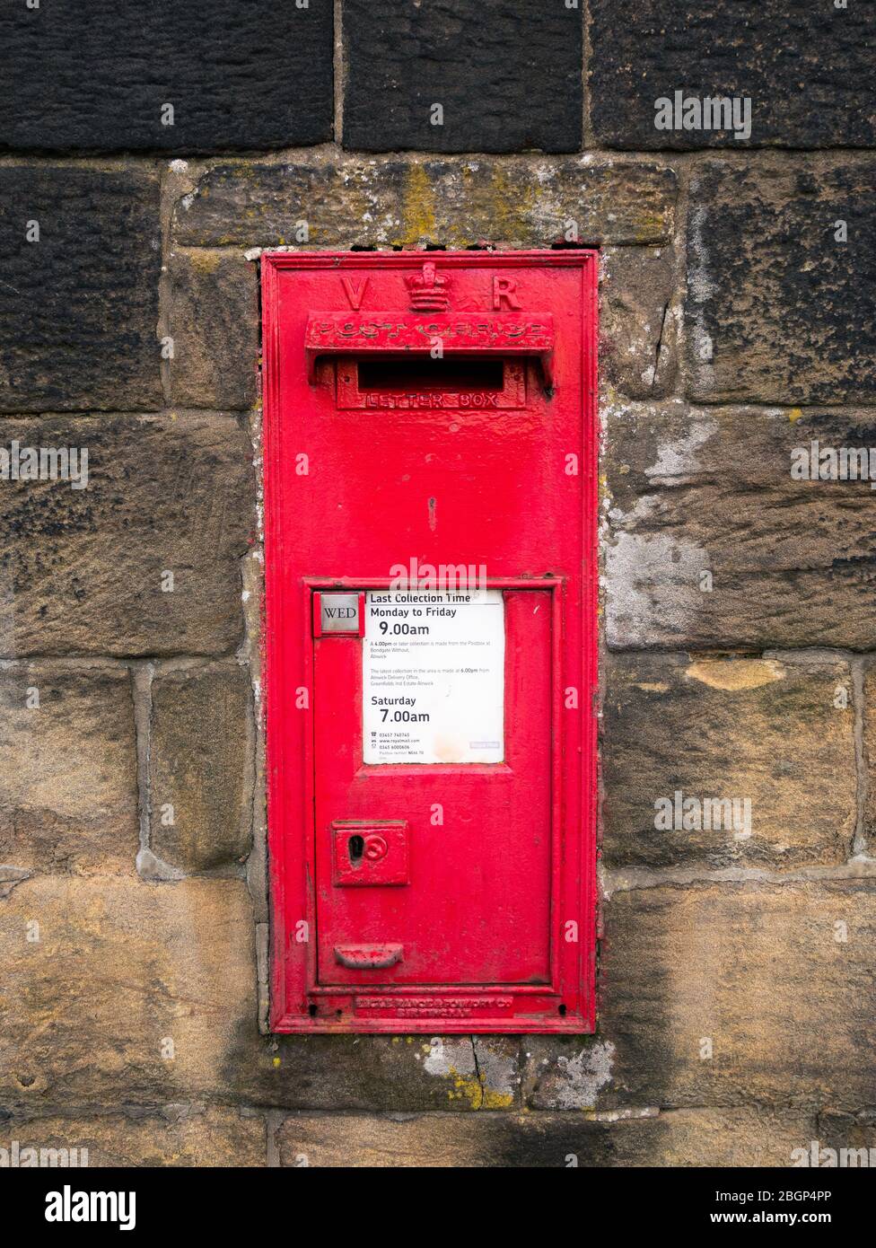 A Queen Victoria era red post box installed in a wall in Northumberland ...