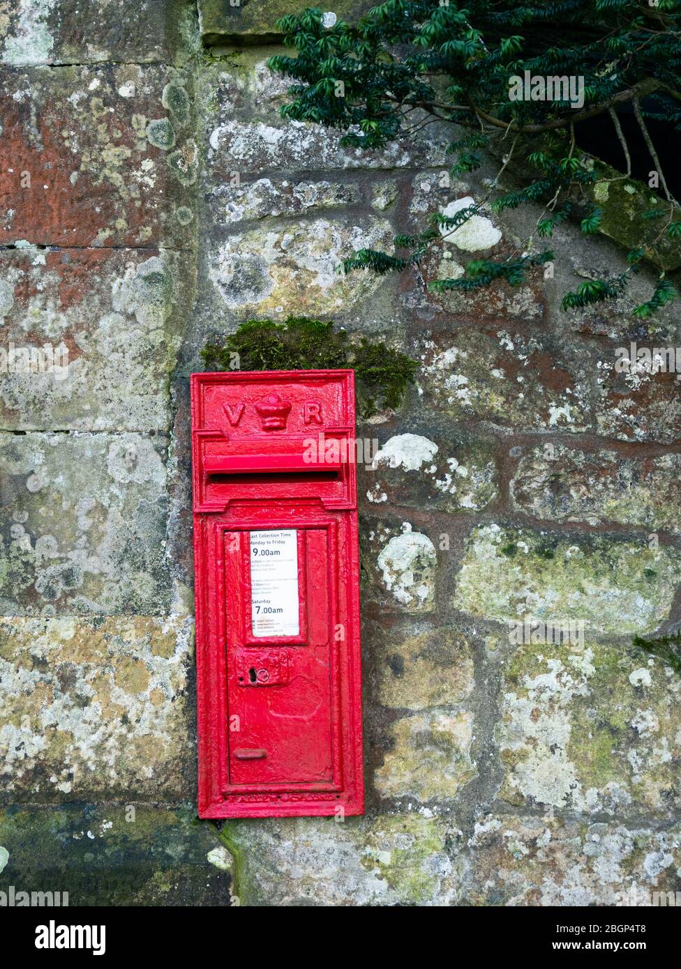 A Queen Victoria era red post box installed in a wall in Northumberland ...