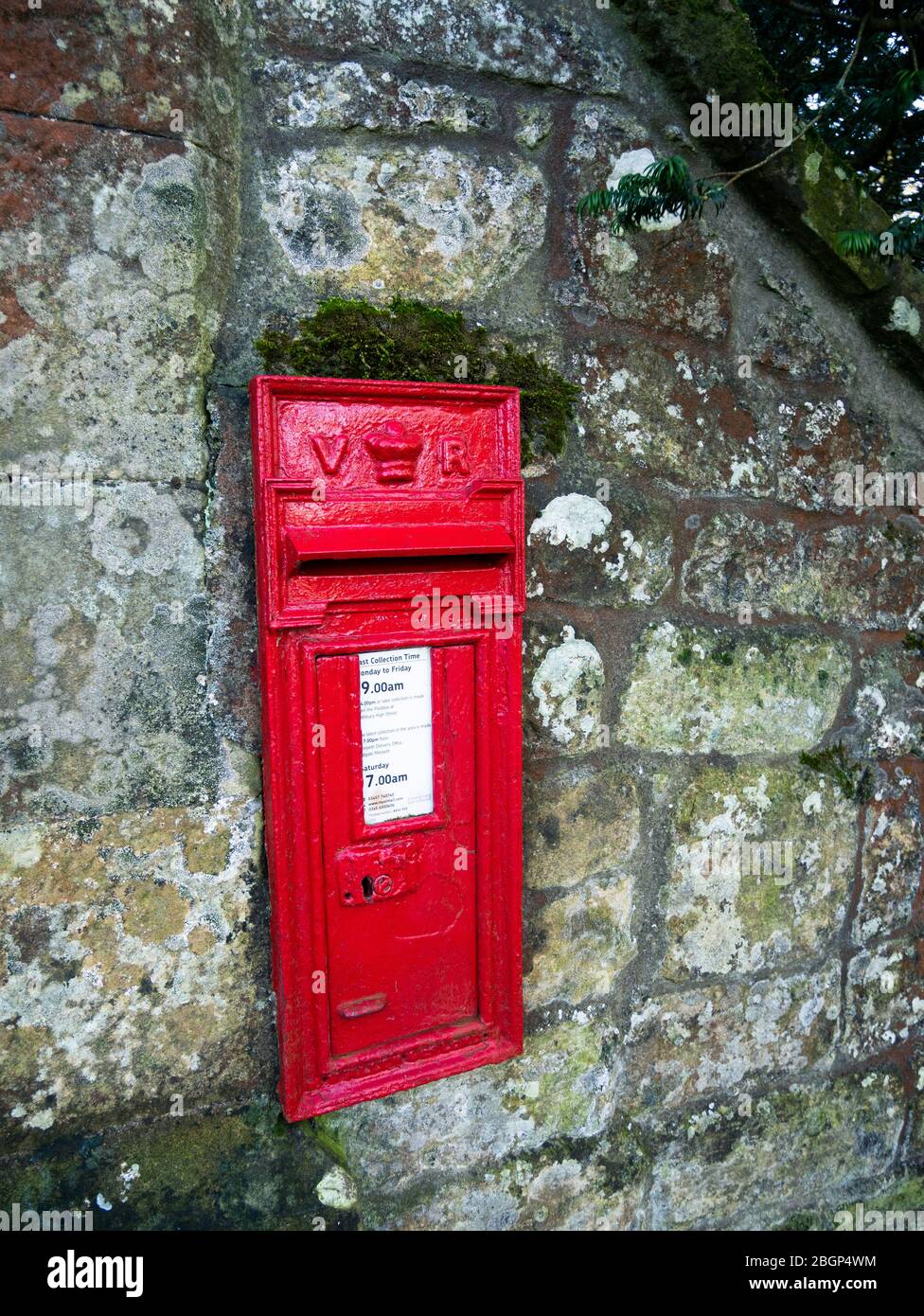 A Queen Victoria era red post box installed in a wall in Northumberland ...