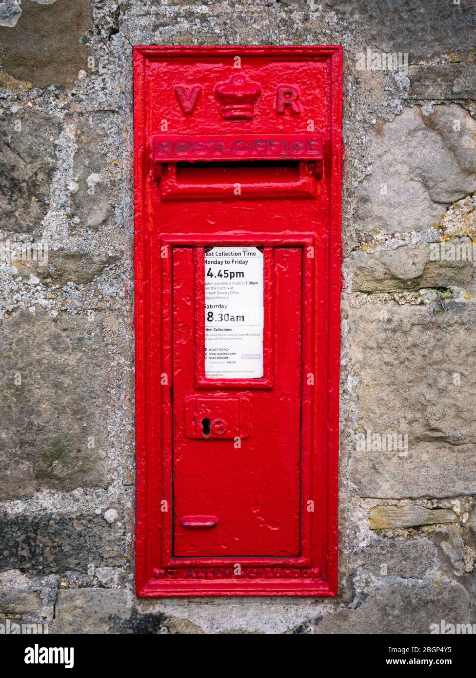 A Queen Victoria era red post box installed in a wall in Northumberland ...