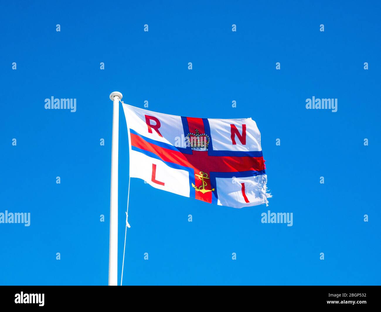 A slightly shredded RNLI flag flutters in the wind in Amble ...