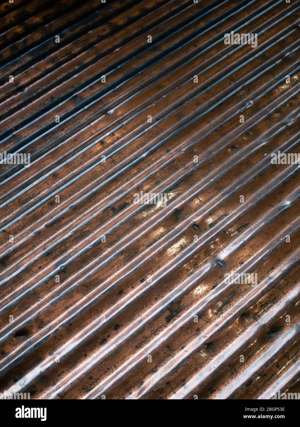 A sheet of corrugated metal, bent and scratched from heavy use over the ...