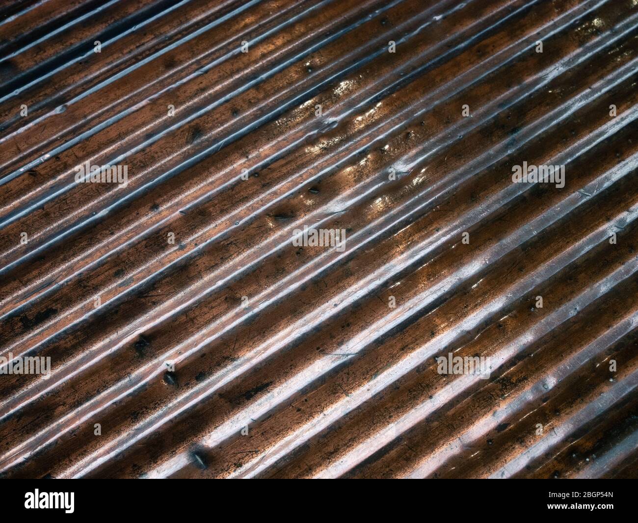 A sheet of corrugated metal, bent and scratched from heavy use over the ...