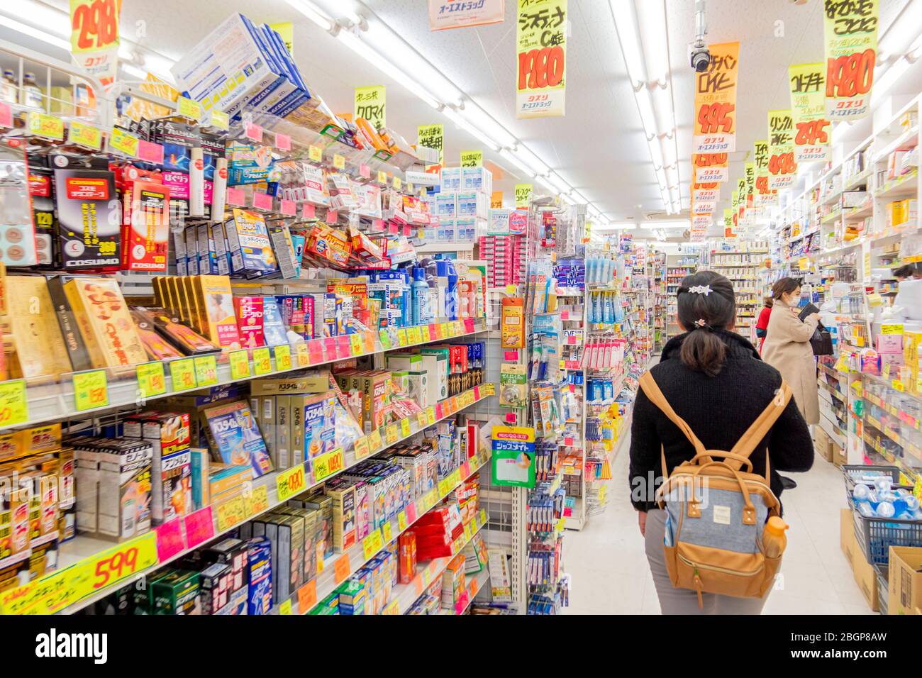 A woman in drug store in Tokyo which has so many kinds of medicine ...