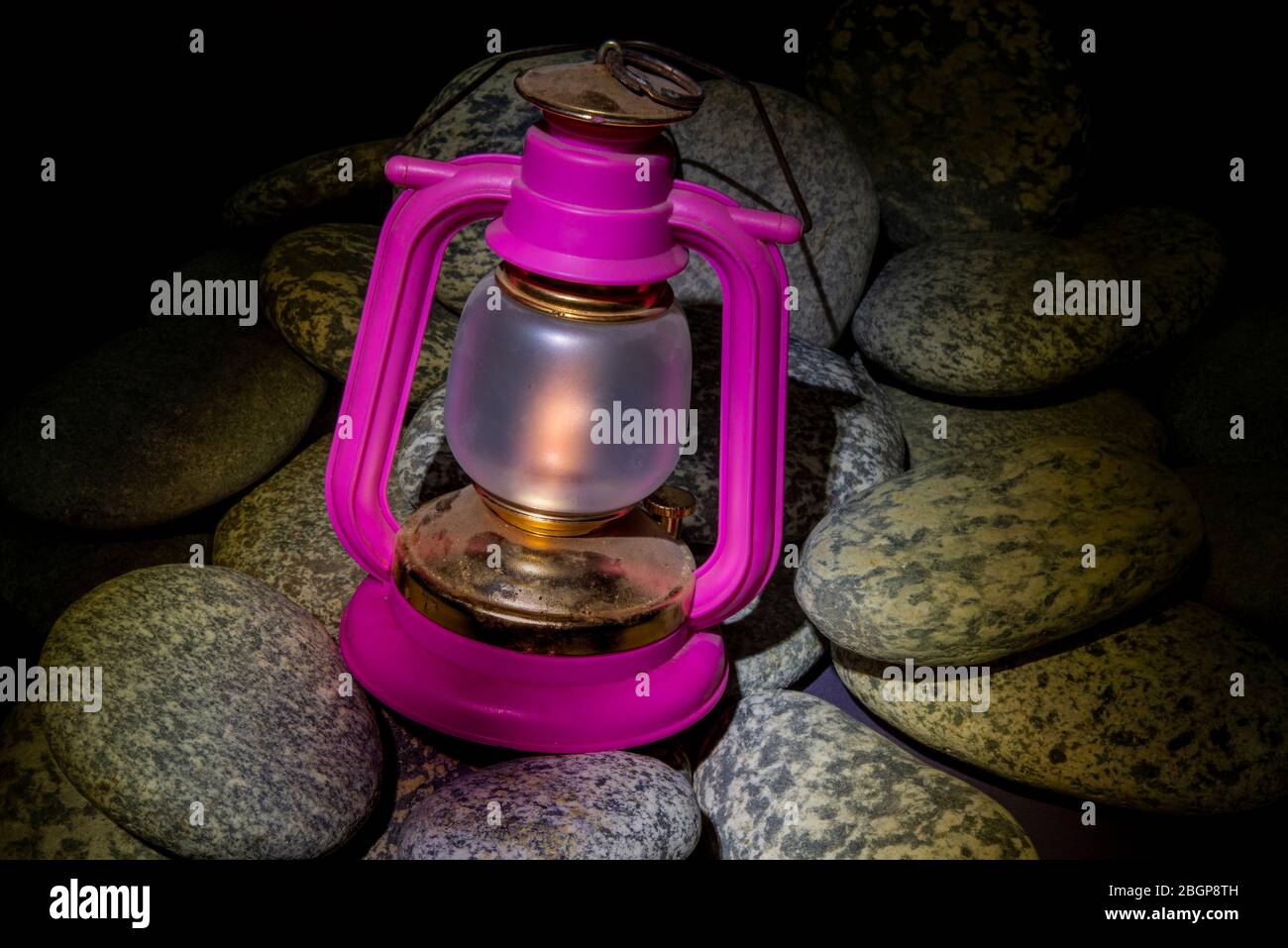 Vintage Lantern burning inside cave with stones around Stock Photo - Alamy