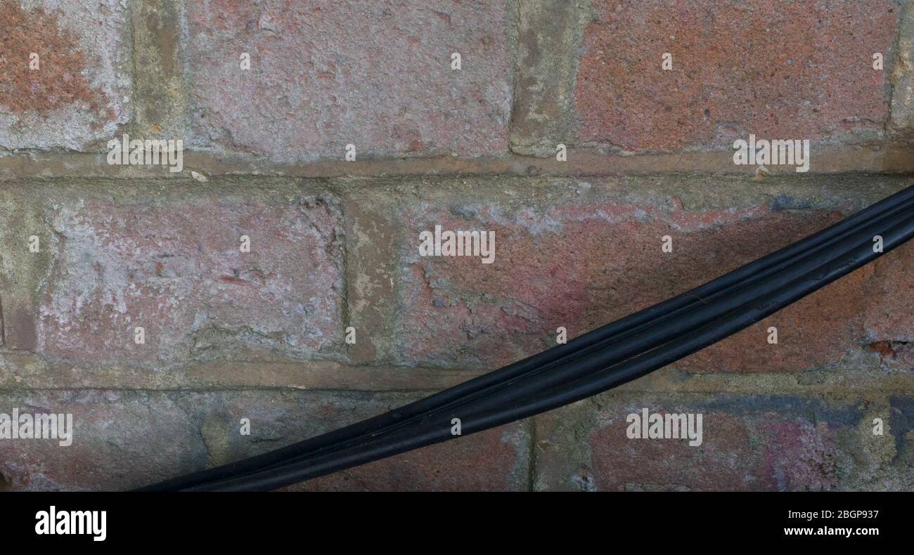 Brick wall with electric wire diagonally across one corner Stock Photo ...
