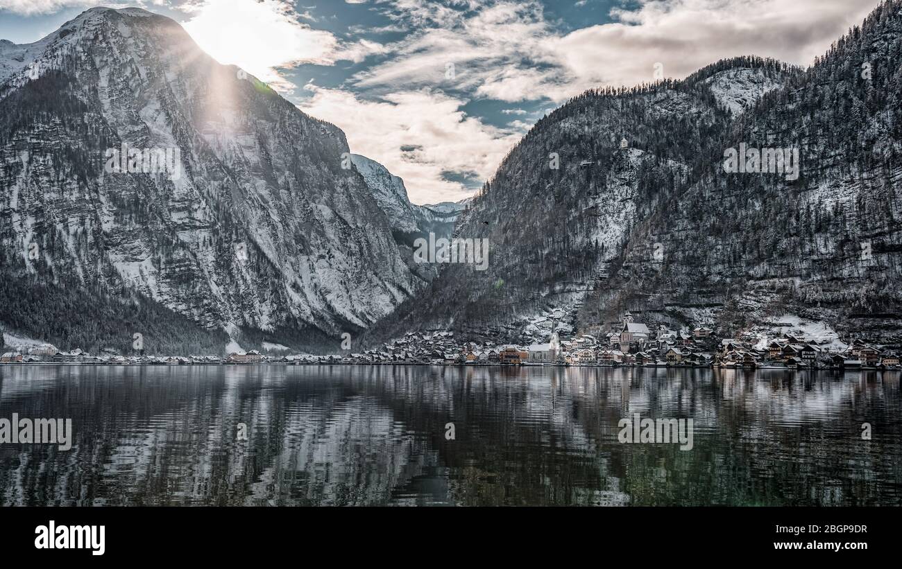 Snowy village Hallstatt at the foot of mountain with sun light in ...