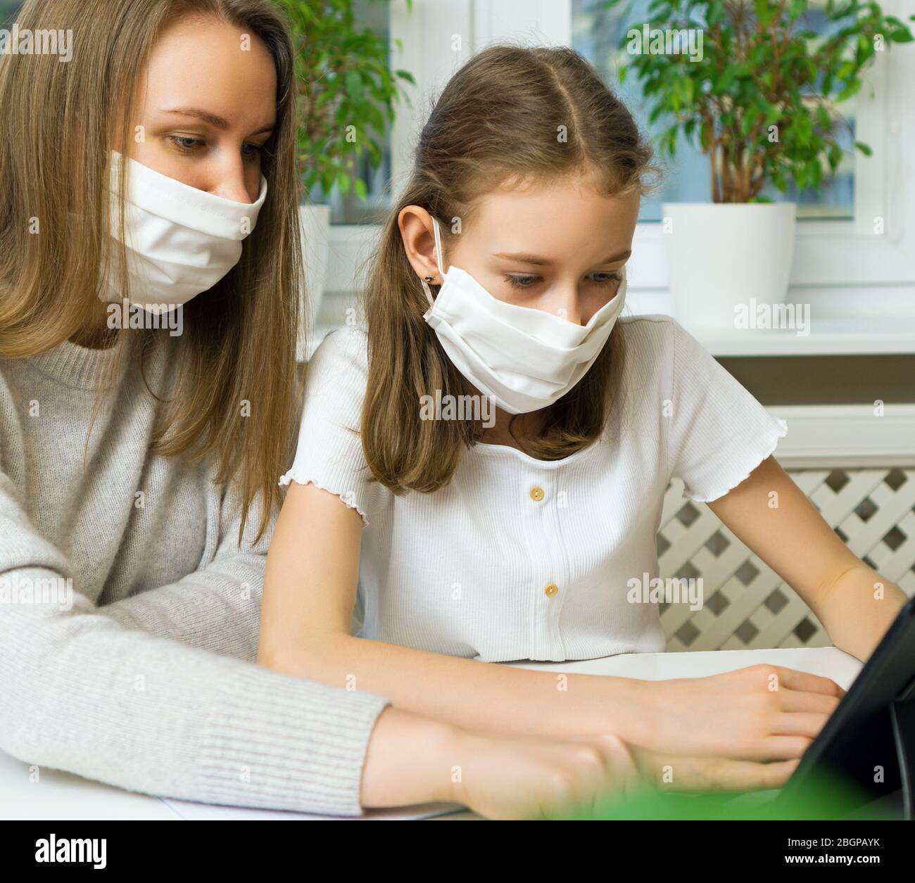Schoolgirl with her mother at distance learning. Home schooling concept ... Schoolgirl with her mother at distance learning. Home schooling concept ...