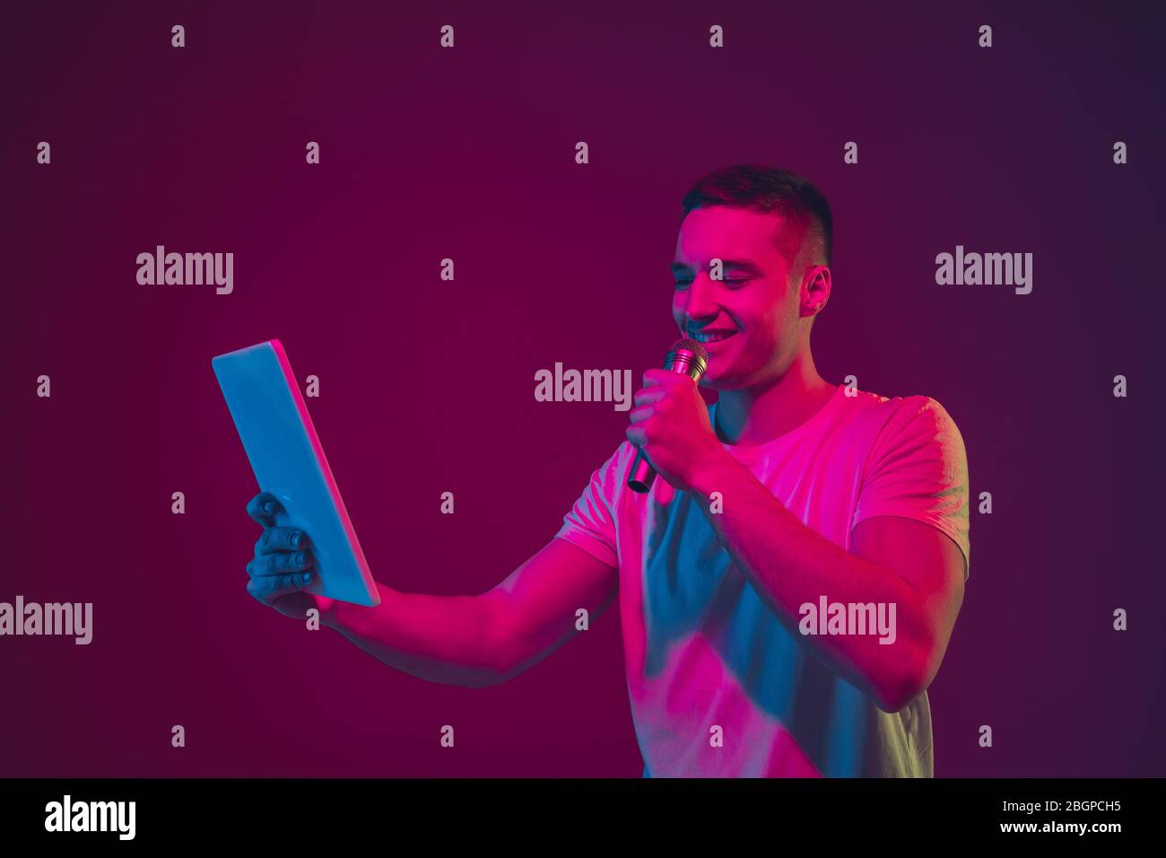 Selfie, vlog, singing. Caucasian man's portrait isolated on pink-purple ...