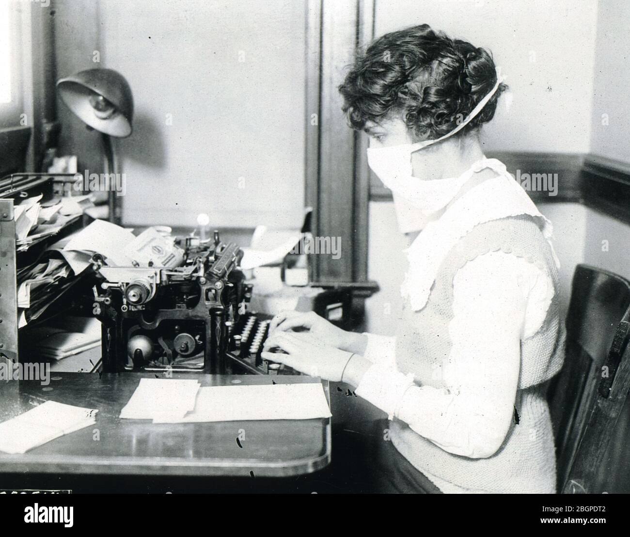 Female typist wearing a mask at work during the Influenza Epidemic of ...