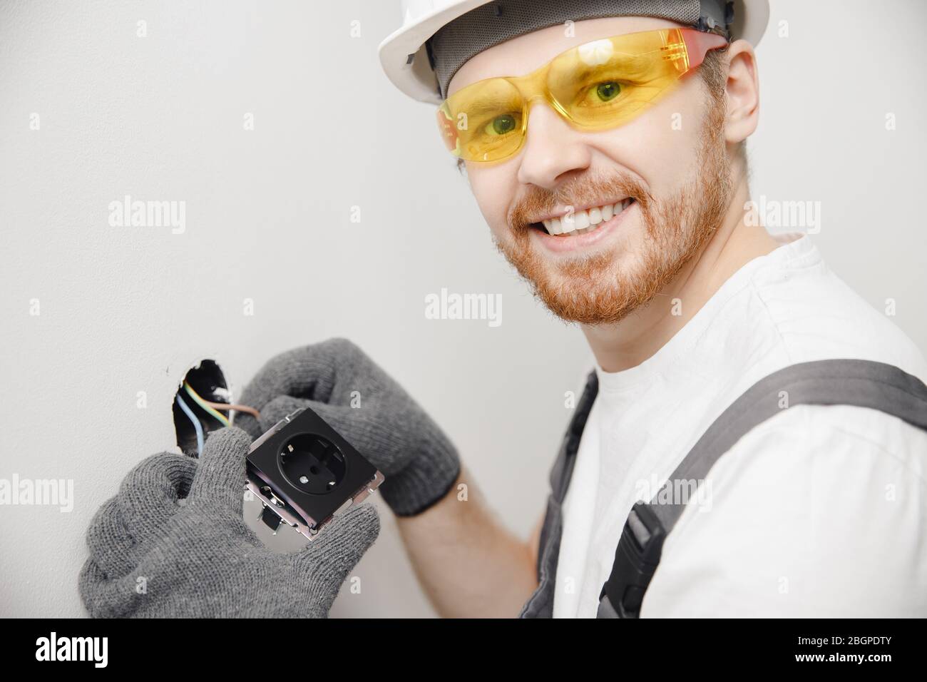 Electrician builder working switches and sockets of residential ...