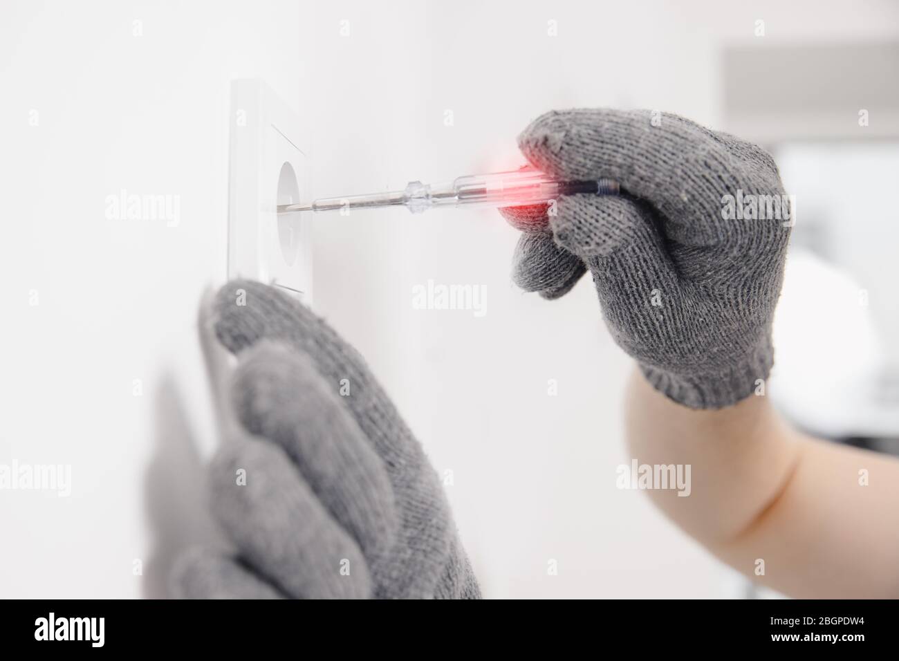 Electrician checks device for electricity voltage power outlet sockets ...