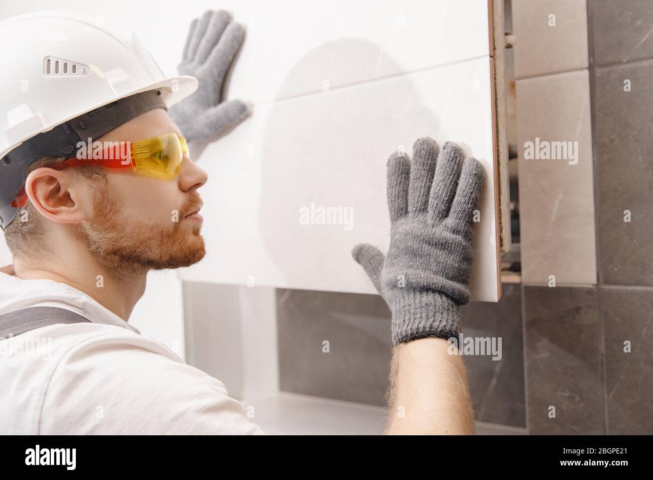 Plumber installing countersunk invisible hatch for water meter shower ...