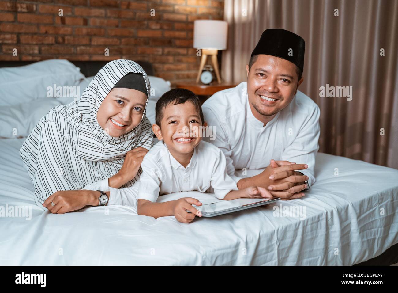 muslim family and son using tablet on the bed during bedtime Stock ...