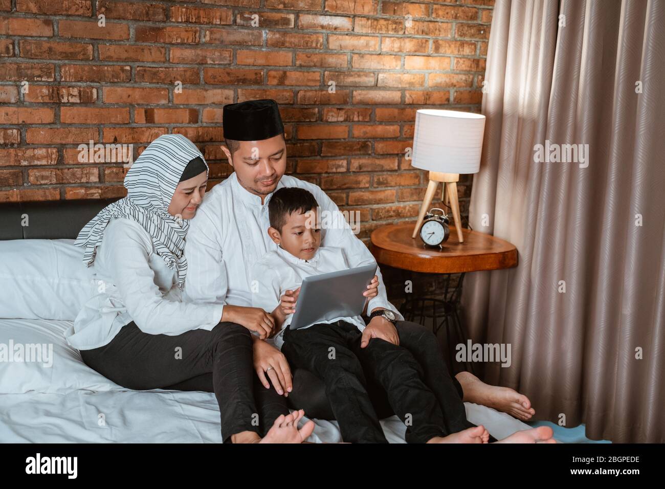muslim family and son using tablet on the bed during bedtime Stock ...
