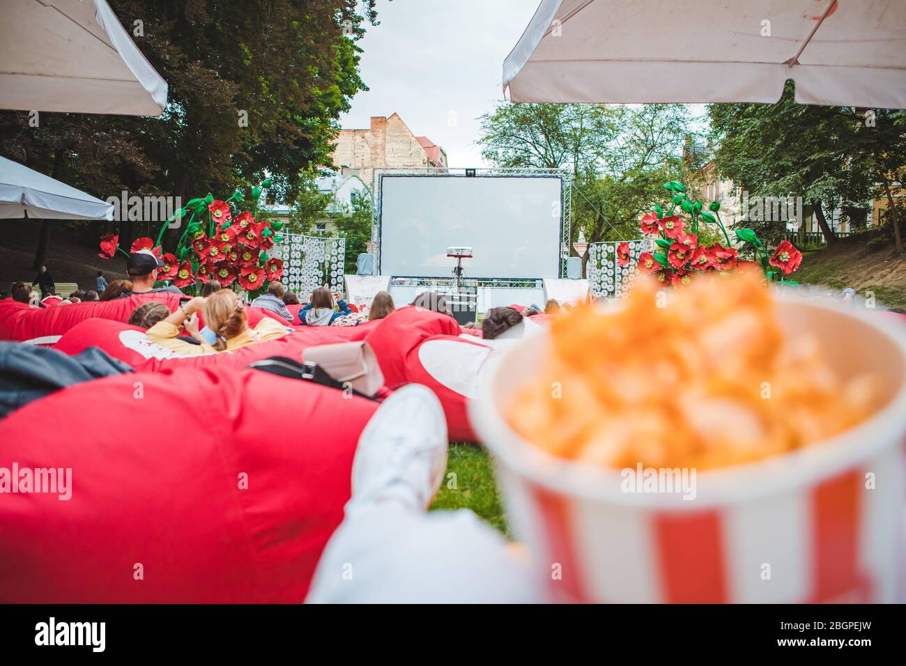 laying eating snacks watching movie at open air cinema Stock Photo - Alamy