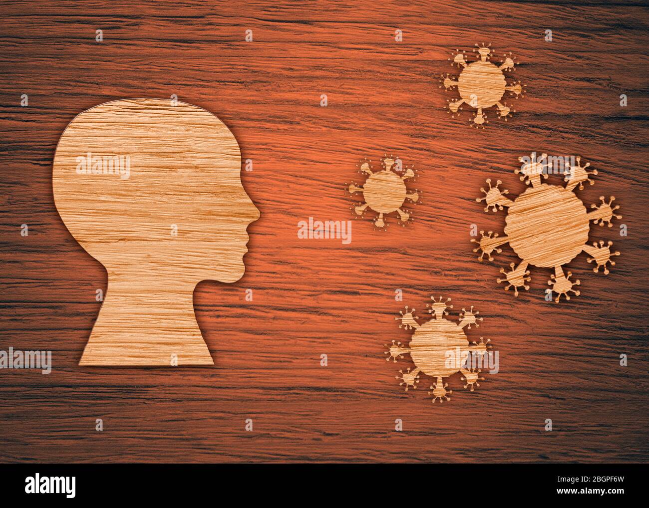 The silhouette of a human head, the virus on a brown wooden background ...